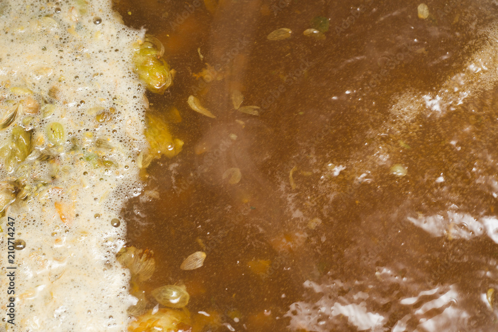 The initial stage of fermentation of craft beer with petals of hop on ...