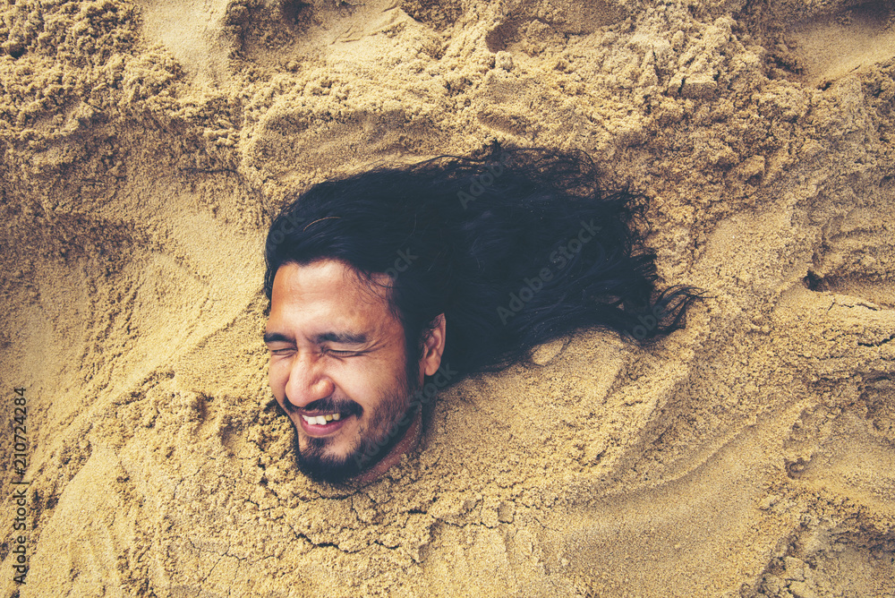 Man buried in the sand at the beach. concept happiness, vacation, no ...