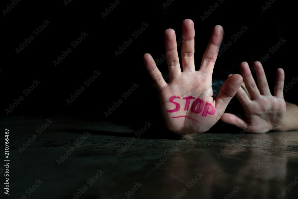 The palm of a female hand giving the signal to stop. The dark, moody ...