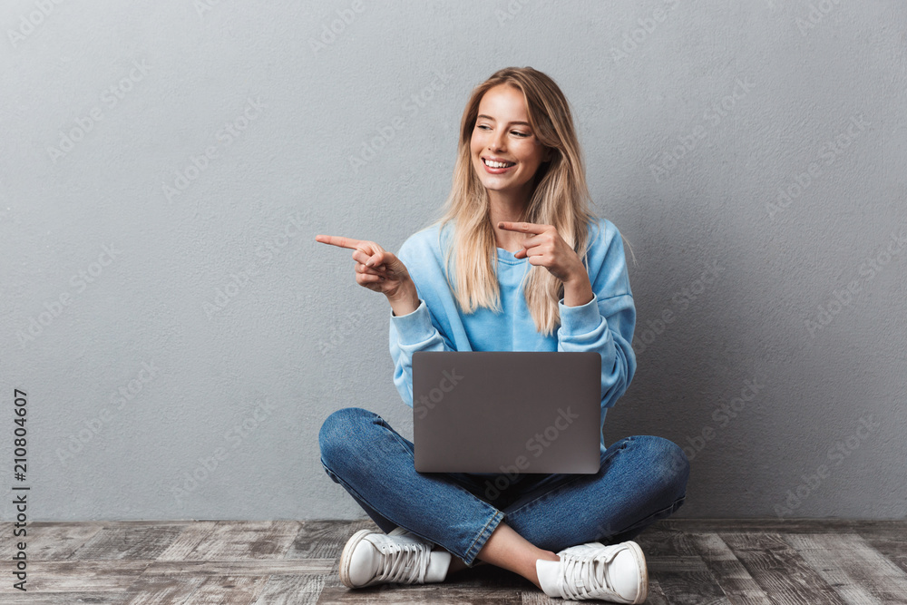 Cheerful young blonde girl using laptop computer Stock Photo | Adobe Stock