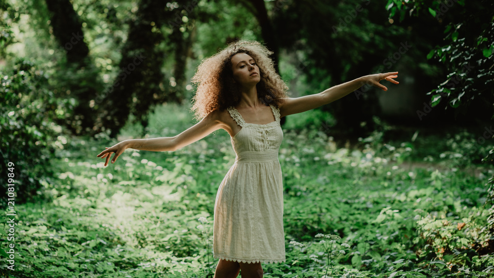 Young and beautiful girl dancing ballet in the secret garden. Natural ...