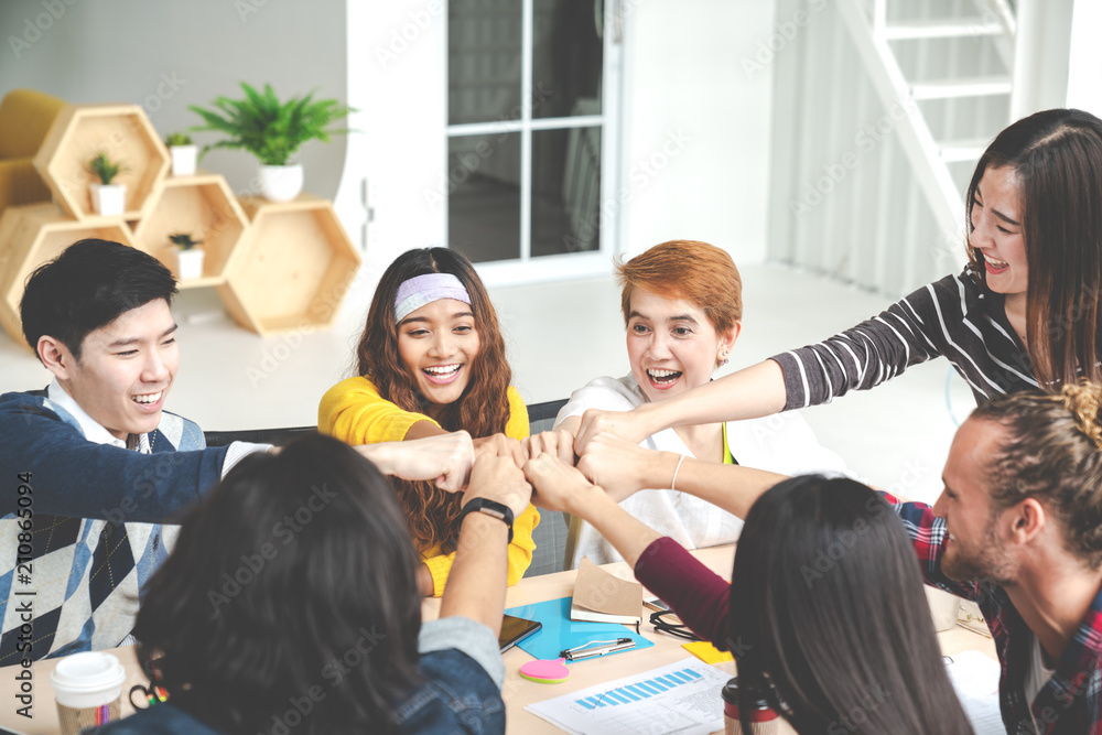 Multiethnic young team stack hands together as unity and teamwork in ...