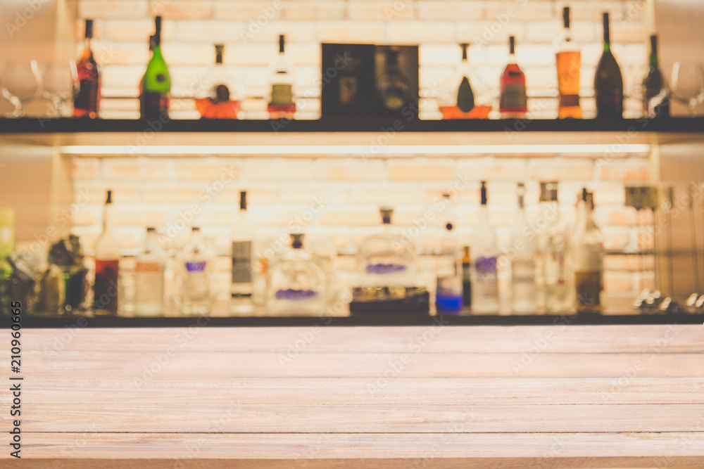 Empty pine wooden bar counter with blur background bottles of ...