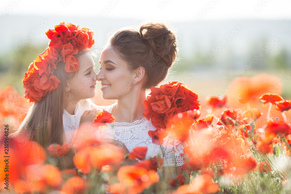 Mother and daughter into a field of poppies.Beautiful mother and her ...