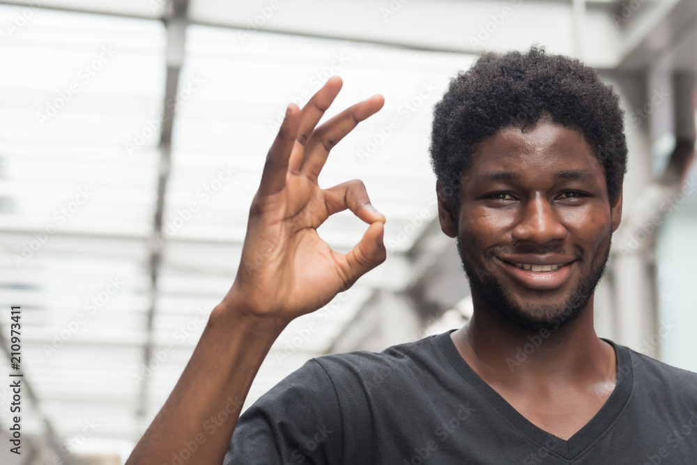successful african man pointing ok or okay hand sign; happy smiling ...