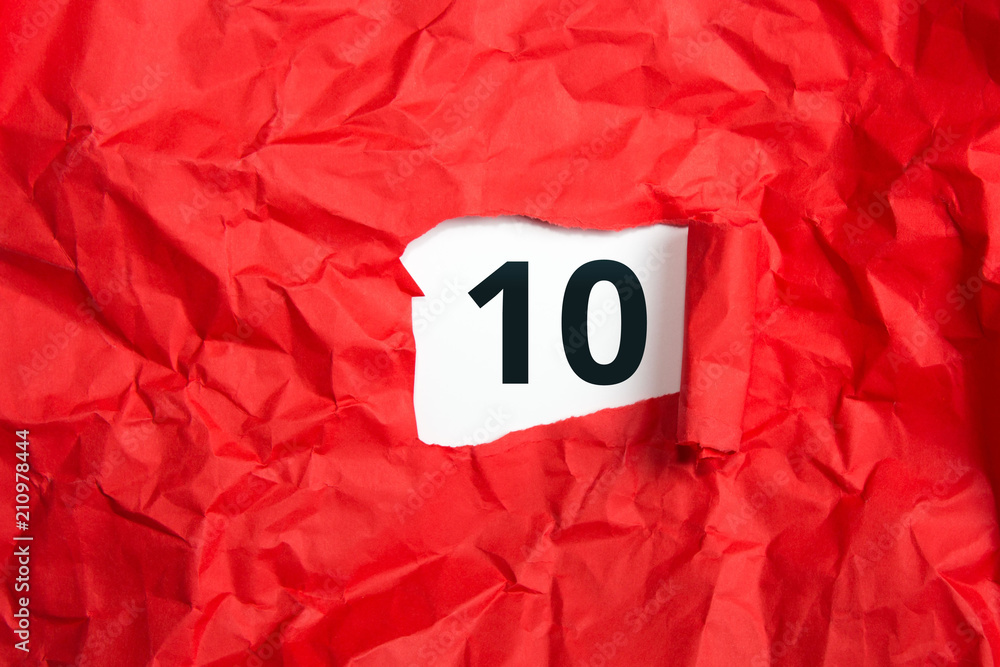 rotes zerknülltes Papier, aufgerollt mit Zahl zehn - 10 auf weißem ...