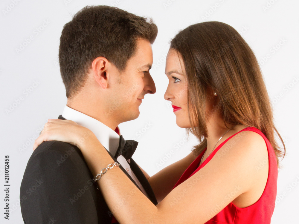 Elegant couple hug and kiss for the camera while holding each other ...