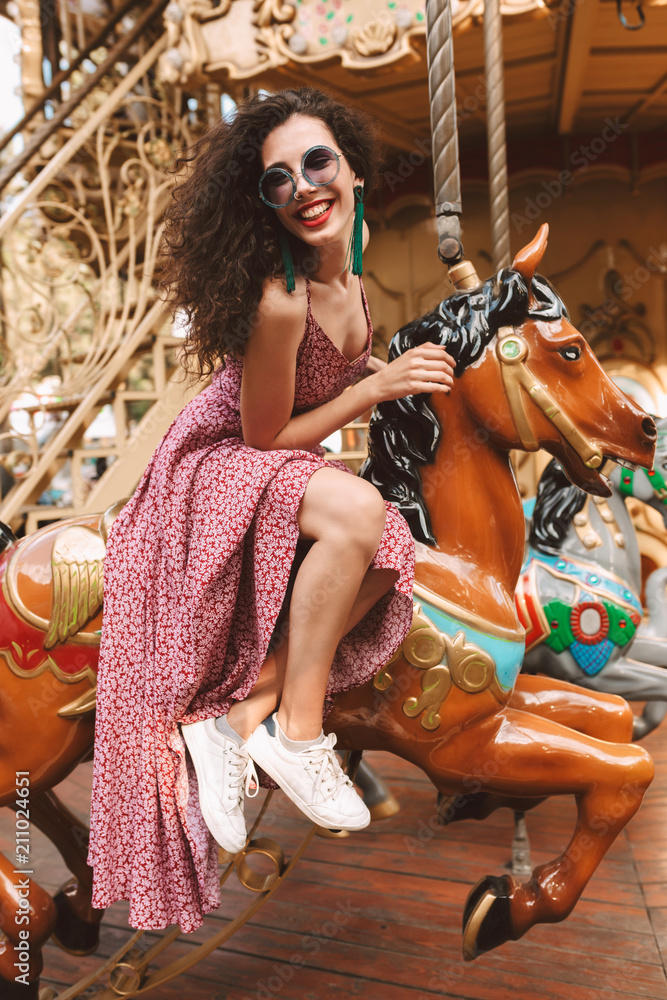 Beautiful smiling lady with dark curly hair in sunglasses and dress ...