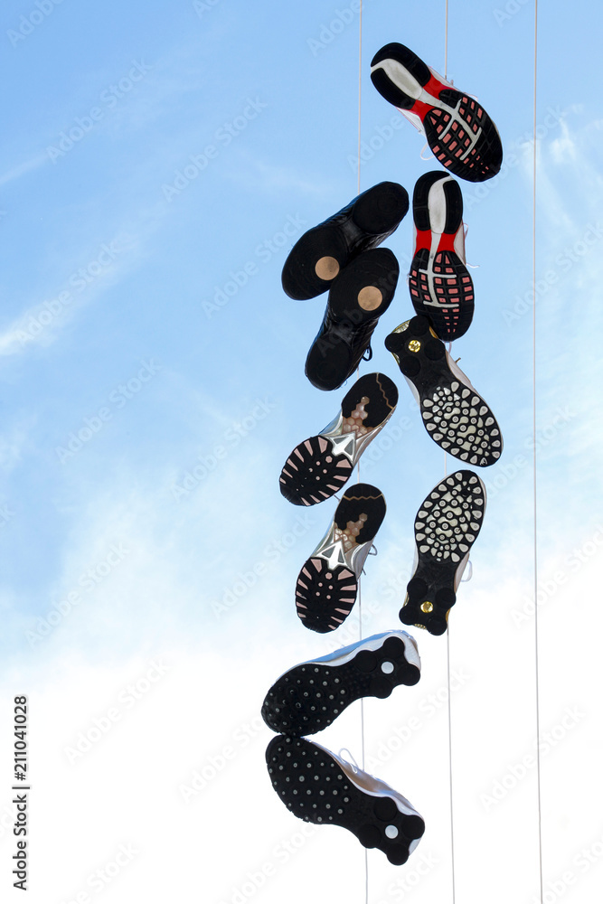 Suole di scarpe da ginnastica viste dal basso perché appese a un filo ...