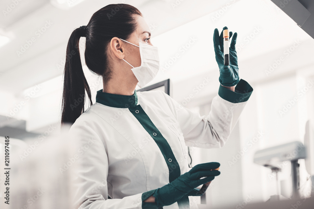 DNA. Profile of experienced concentrated doctor holding blood sample ...