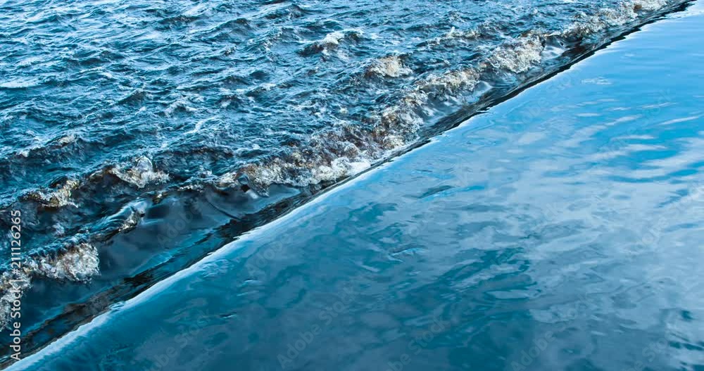 Diagonal Flow. The smooth flow of water turns into a seething splitting ...