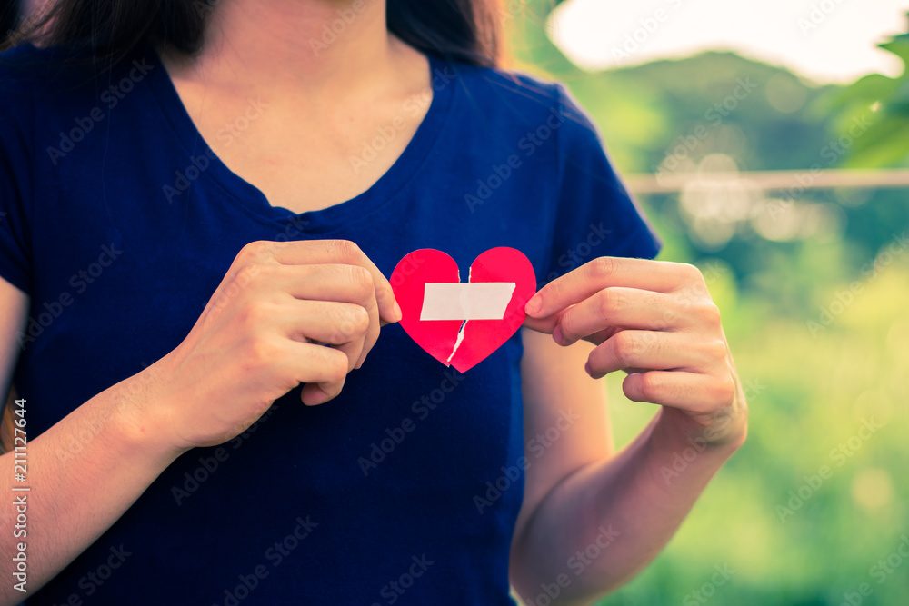Close up woman hands connecting torn pieces of hart,Female hands ...