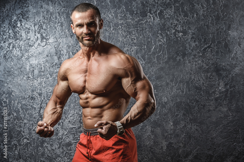Strong and muscular bodybuilder showing his body Stock Photo | Adobe Stock