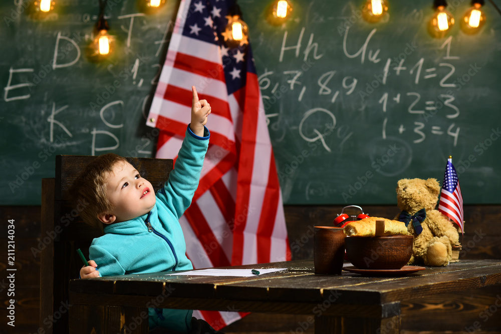 School child with the USA flag, background green blackboard in the ...
