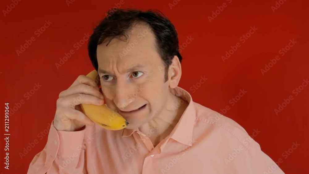 A funny ugly man talking on a banana phone, getting nervous. Red ...