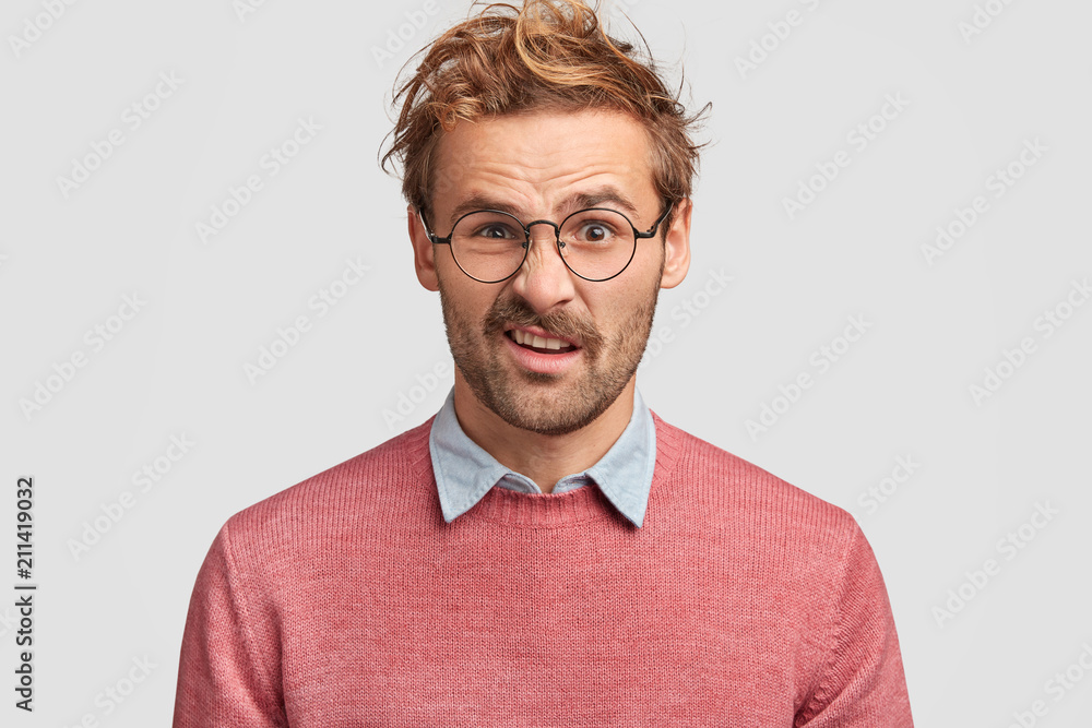 Handsome displeased male frowns face with discontent, feels aversion as ...