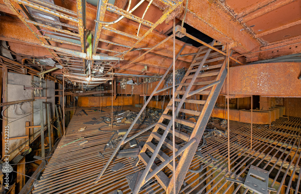 Completely rust-covered iron room with iron stairs in an abandoned old ...