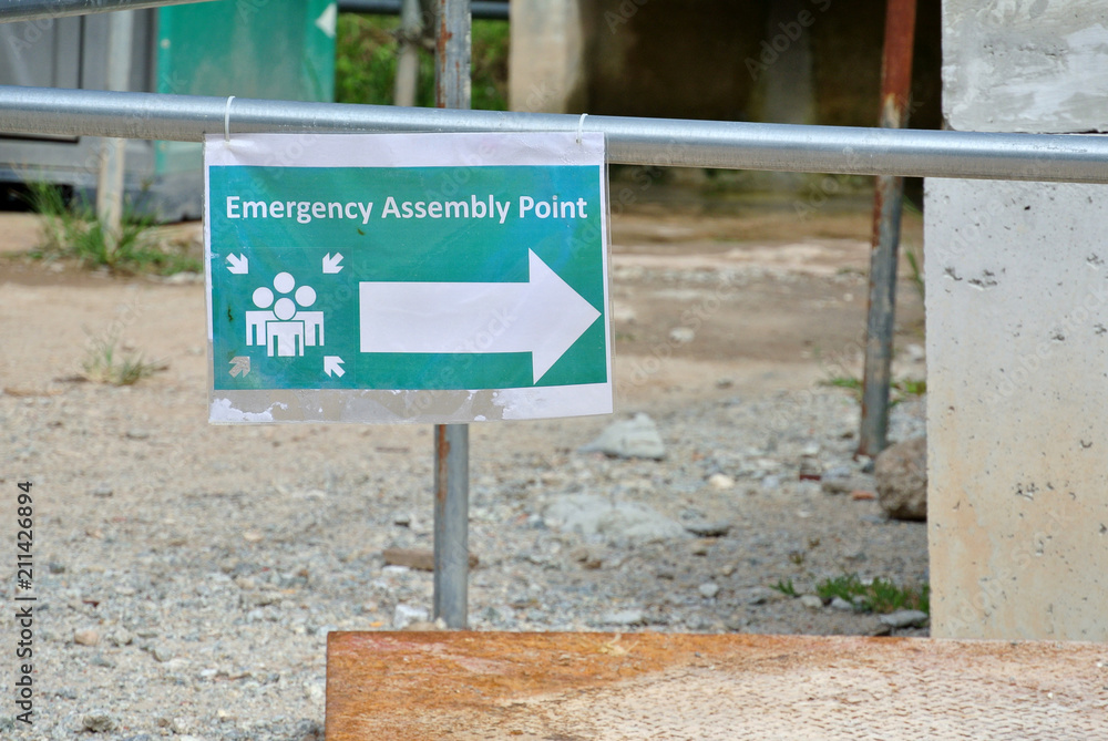 Safety signage "Emergency Assembly Point" with direction arrow at the ...