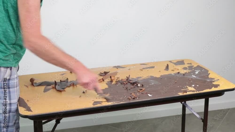 Video „Male scraping an old wood grain pattern tabletop sticker from a ...