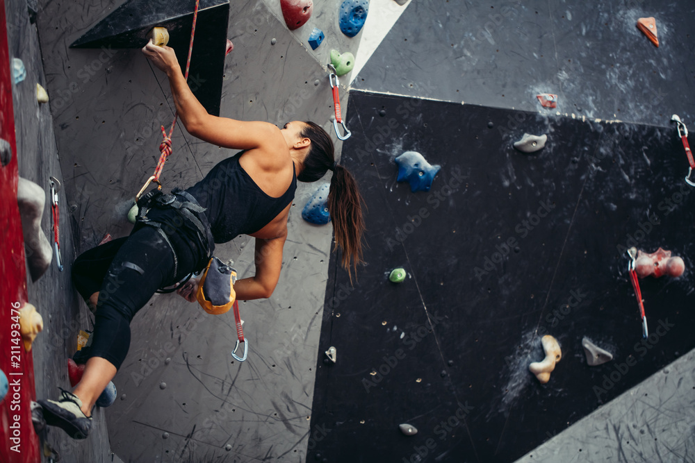 Professional climber woman in black outfit, reaching the top of ...