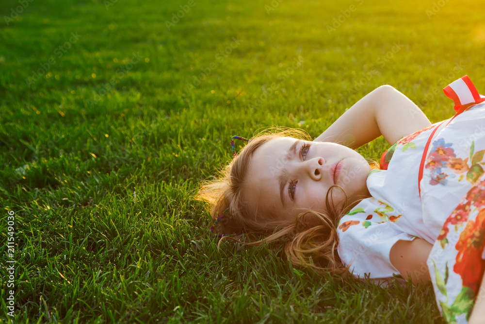 Beautiful young girl lying on the grass, looking at the sky Stock Photo ...