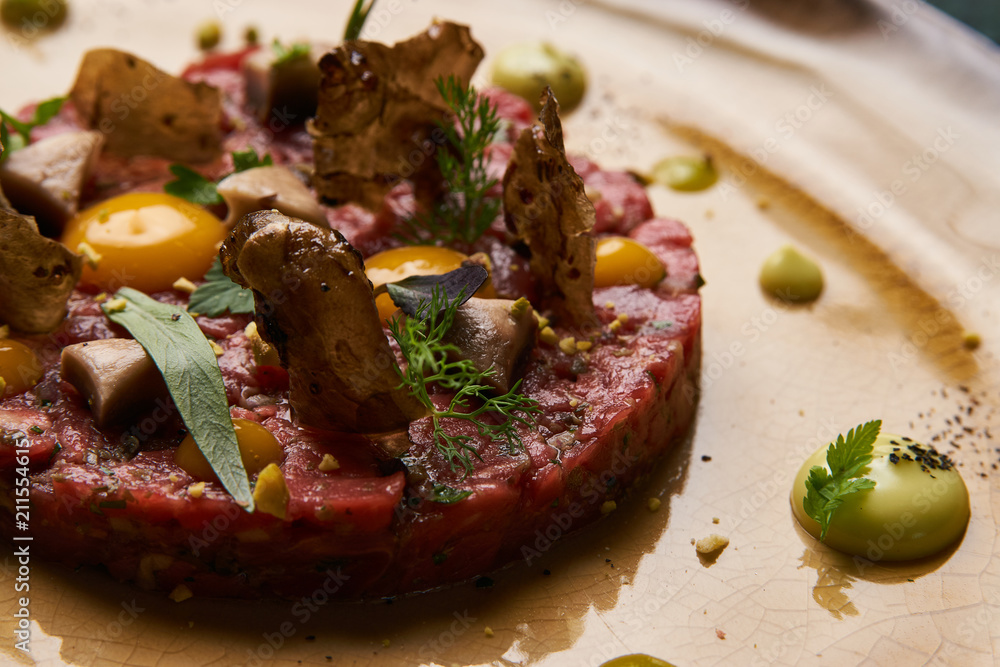Beef tartare Steak with egg yolk, pistachios, truffle oil, green ...