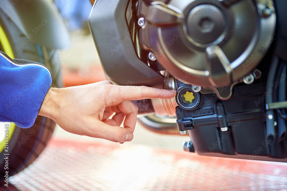 Repair of motor cycle - oil level check Stock Photo | Adobe Stock