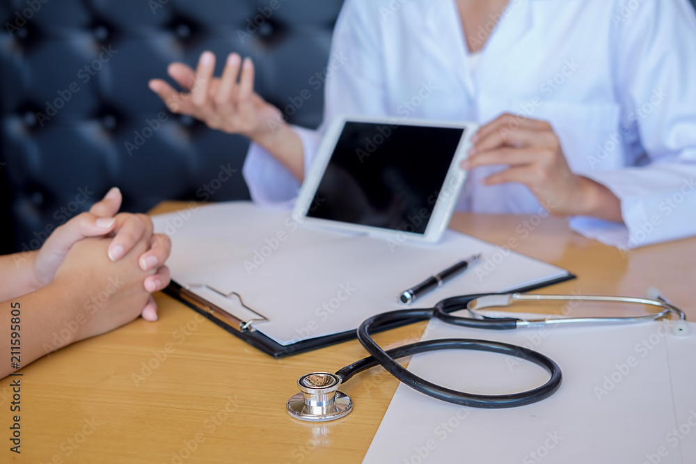 Patient listening intently to a male doctor explaining patient symptoms ...