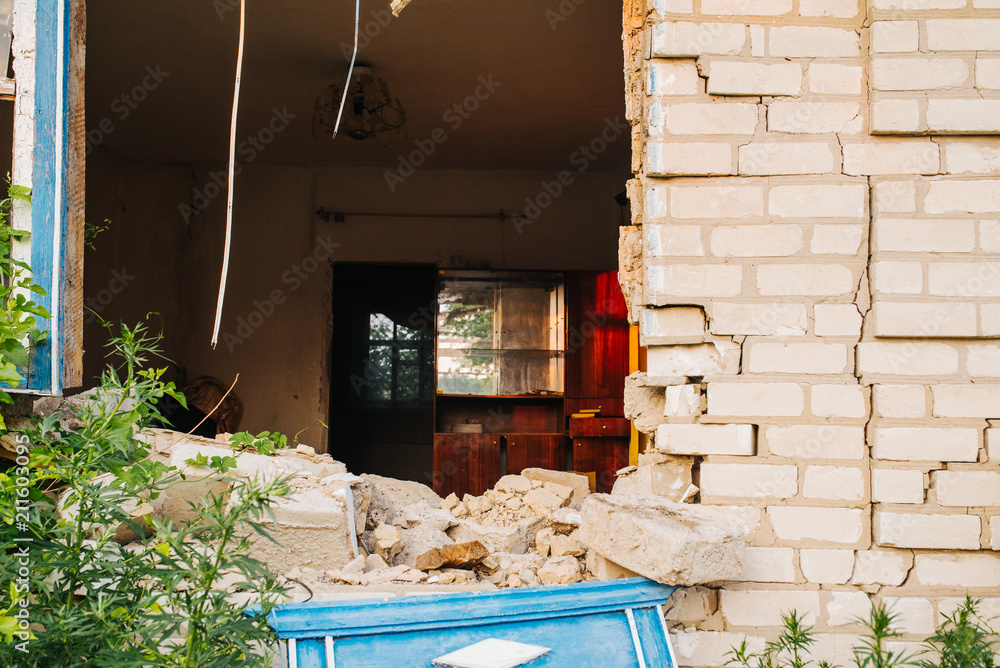 Ruined wall of the house. Hit a military projectile after a car ...
