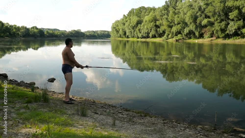 Fishing in river.A fisherman with a fishing rod on the river bank ...