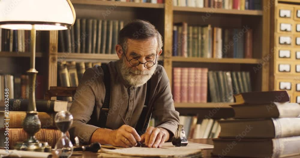 Portrait of the senior man writing on the old paper while sitting in ...