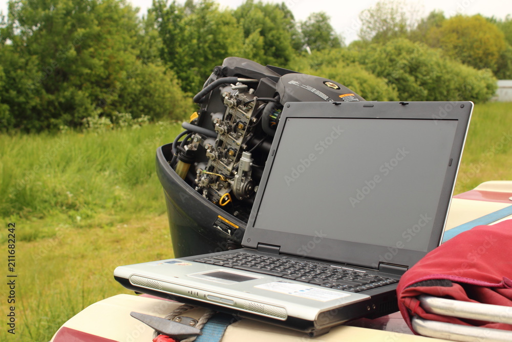 Computer diagnostics of ships - a laptop on the stern of a plastic boat ...