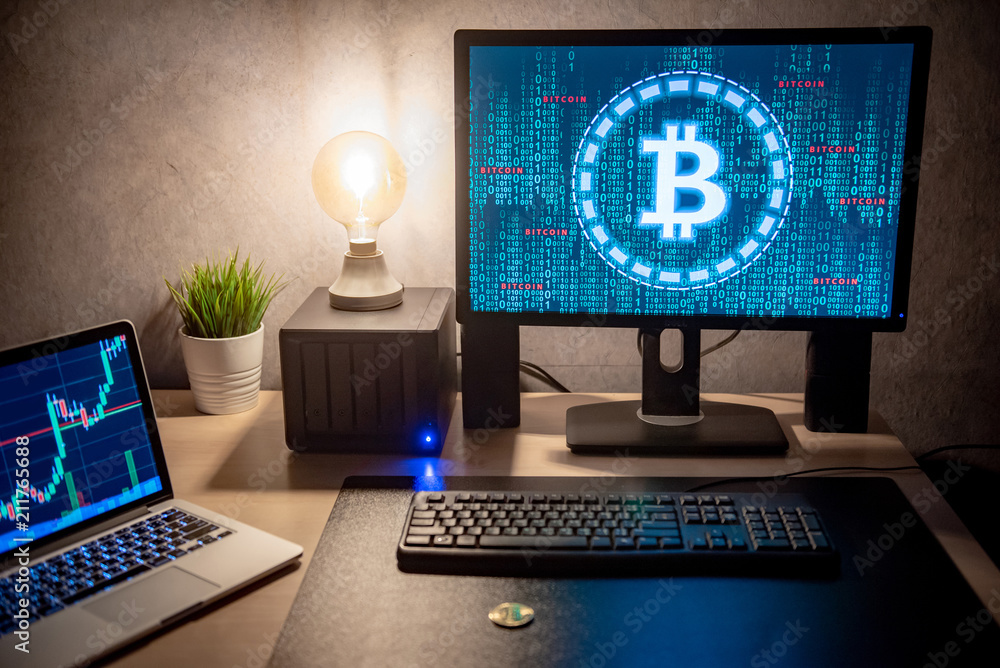 Bitcoin gold coin on computer desk with green bitcoin graphic ...