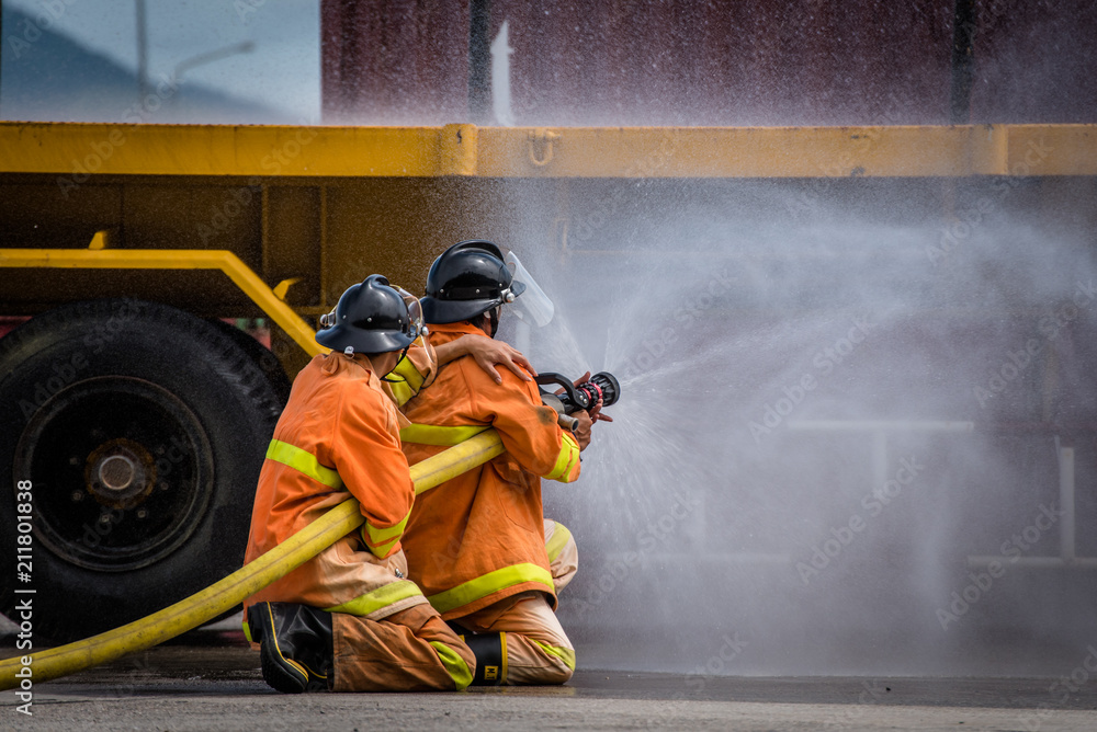 Fireman using water and extinguisher to fighting with fire flame in an ...