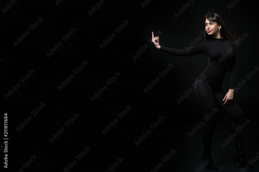 beautiful girl in black shows middle finger. Studio portrait in full ...