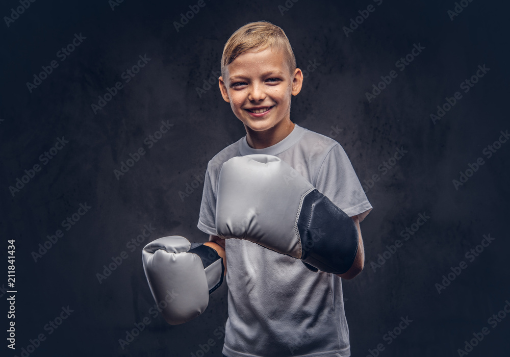 Funny little boy boxer with blonde hair dressed in a white t-shirt ...