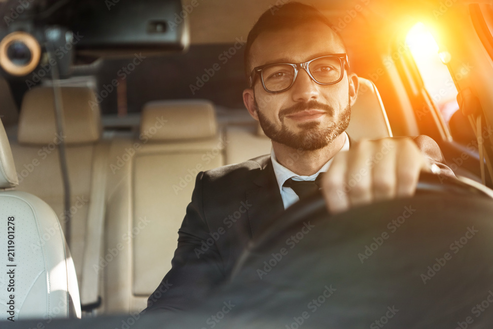 handsome driver in suit driving car during sunset Stock Photo | Adobe Stock