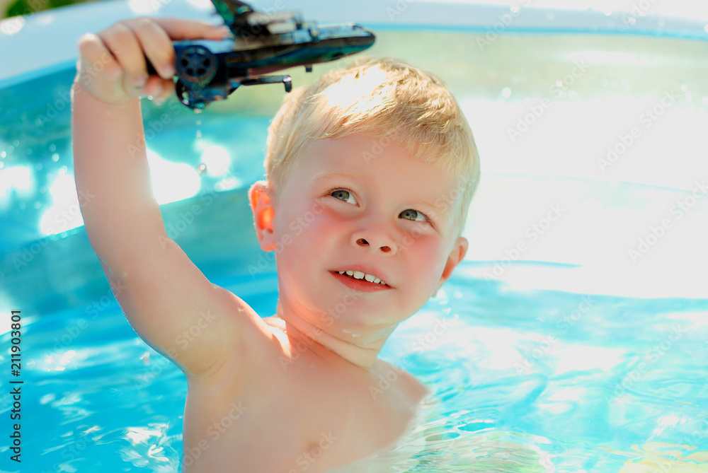 Baby with toy plane in swimming pool. Little boy learning to swim in ...