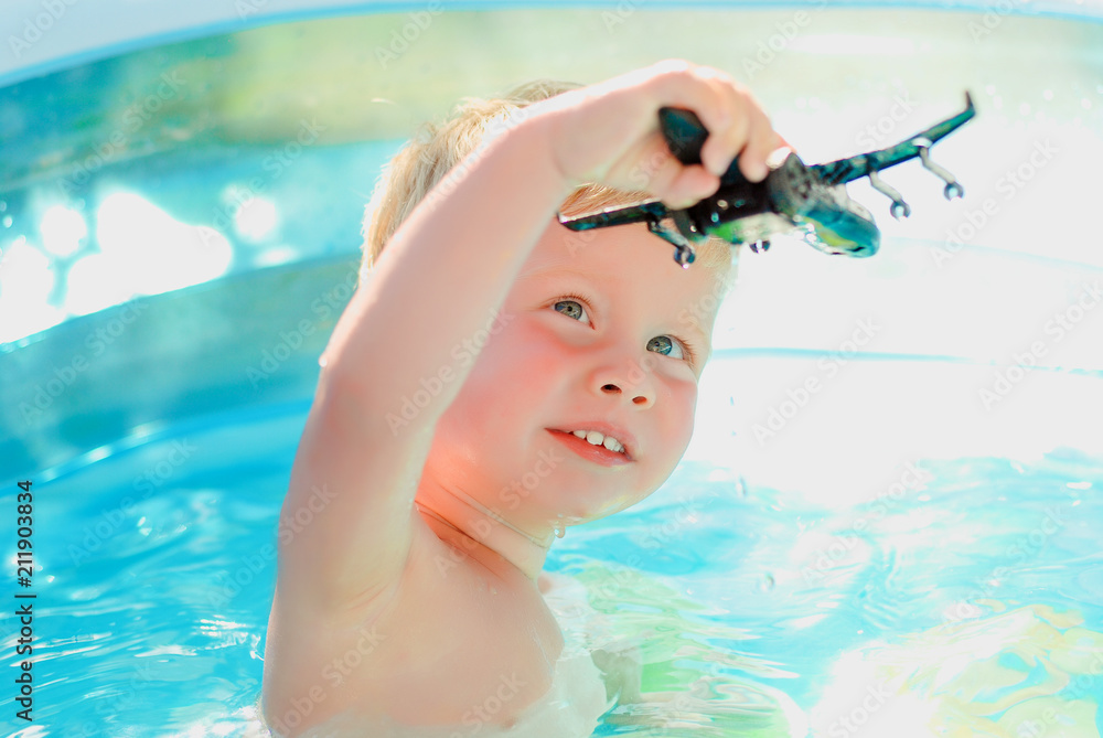 Baby with toy plane in swimming pool. Little boy learning to swim in ...