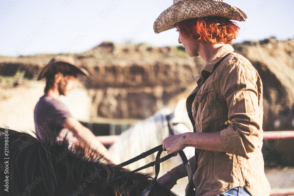 couple of modern cowboy ride together. one man and one woman with two ...