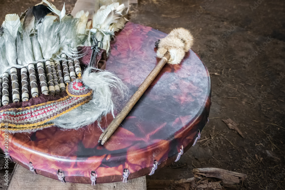 Ancient amerindian tambourine, drum drumstick replica and a feather ...