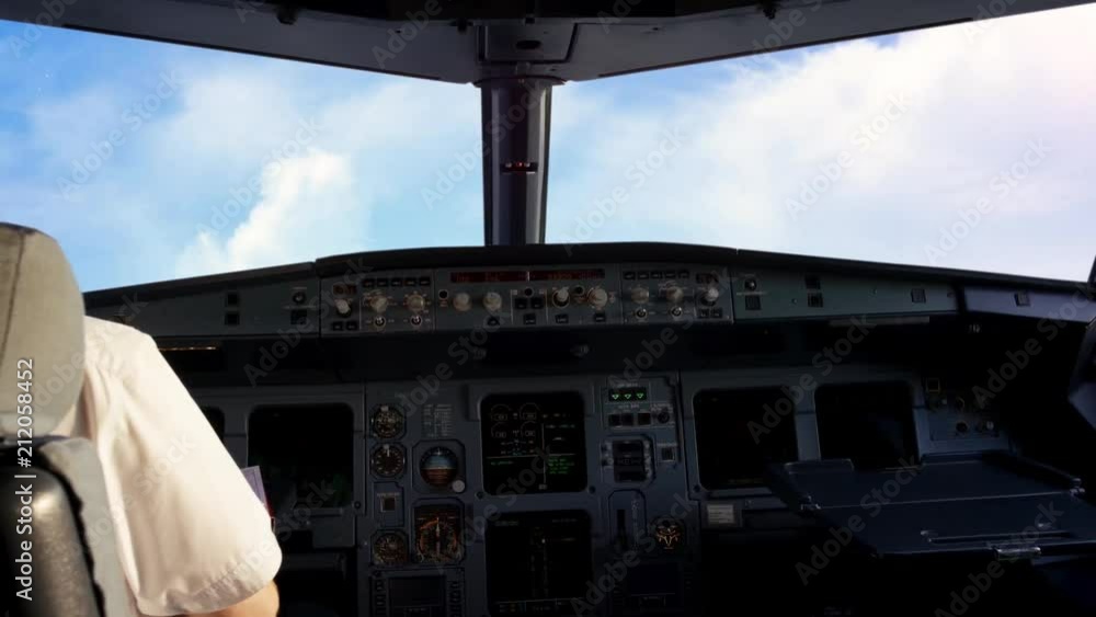 Pilot in the cockpit of a small commercial aircraft above a rural ...