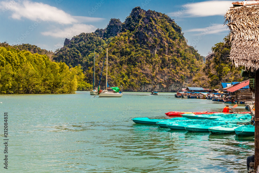 Beautiful scenery of two sailing boats next to a mangrove coastline and ...