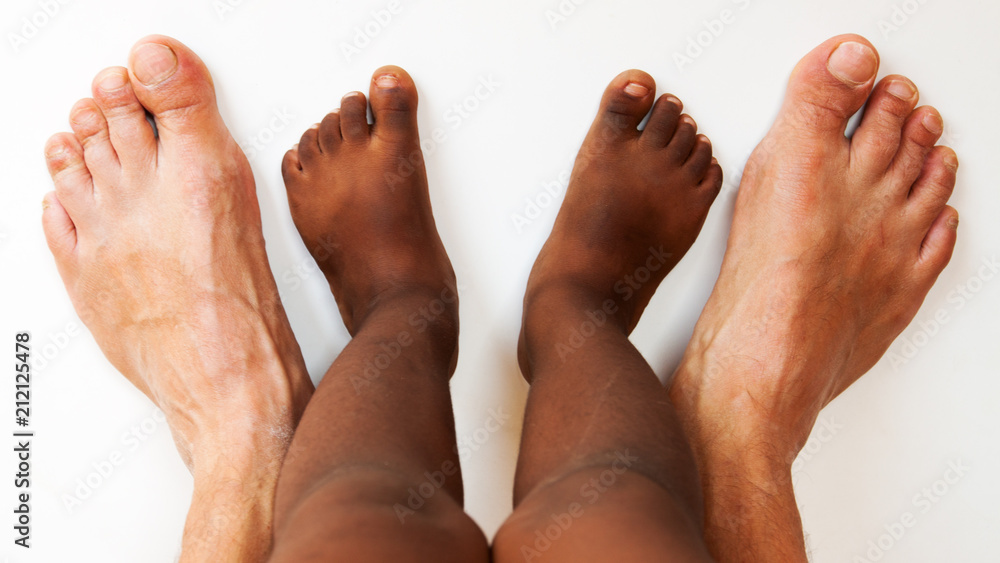 pieds noirs d'enfant avec pieds blancs d'adulte Stock-Foto | Adobe Stock
