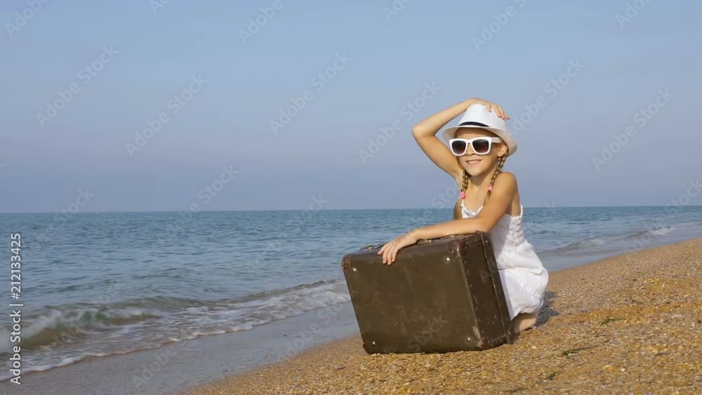 One happy little girl playing on the beach at the day time. Kid having ...
