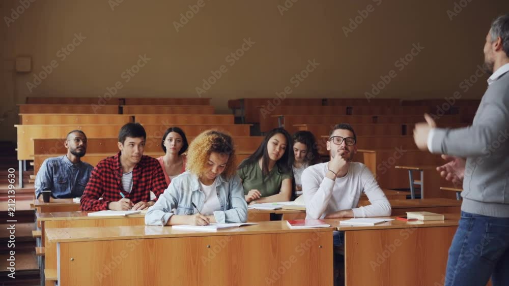 Serious man high school teacher is talking to students then young guy ...