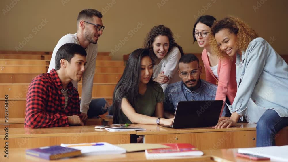 Video Stock Multiracial team of students is working with laptop typing ...