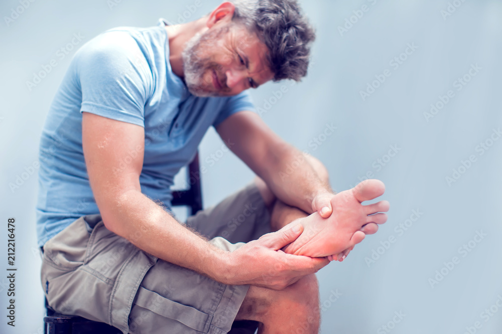 Foto de Man hand holding foot with pain, health care and medical ...