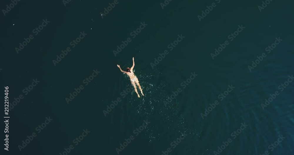 Young woman swimming in beautiful azure sea. Young woman swimming and ...