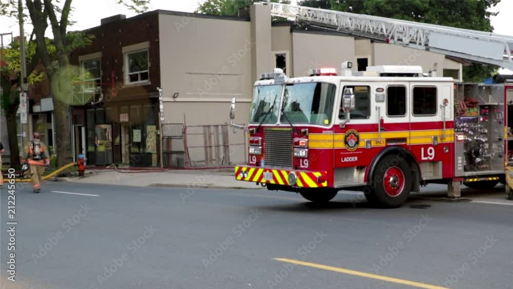 Fire truck with extended ladder at the scene of an urban fire with fire ...